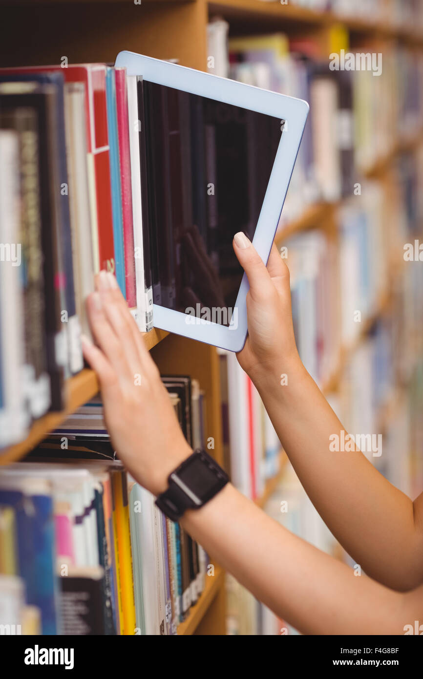 Hands keeping tablet with blank screen in bookshelf Stock Photo - Alamy