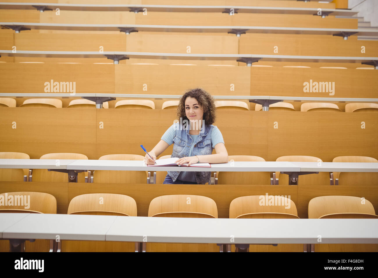 Happy student in lecture hall Stock Photo - Alamy