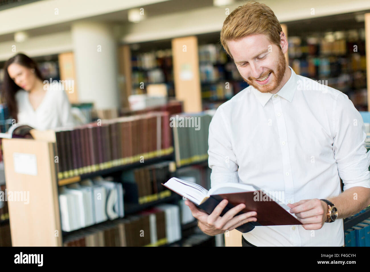 Young man in the library Stock Photo - Alamy