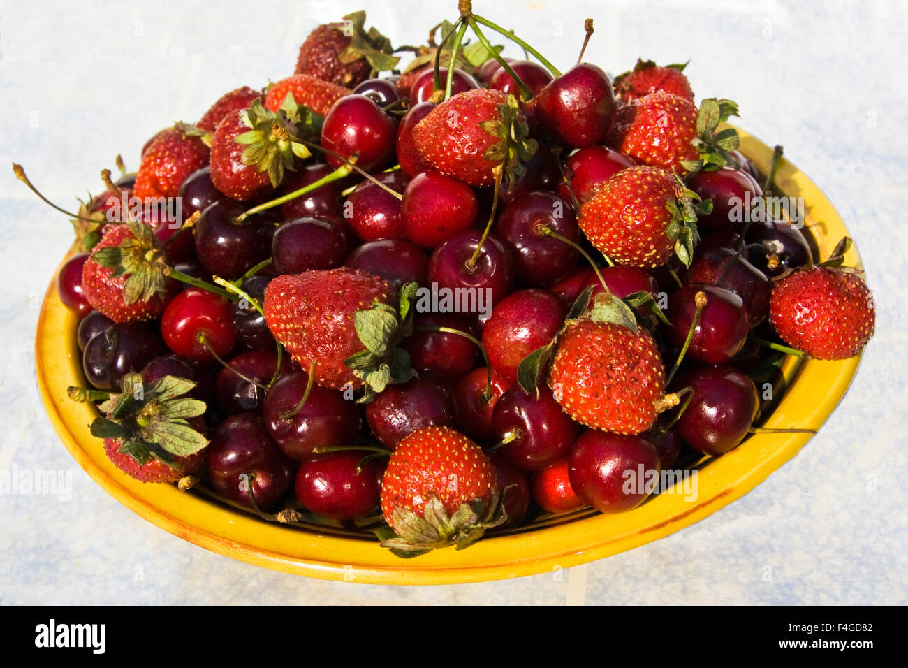Plate with many red cherries and strawberry Stock Photo - Alamy