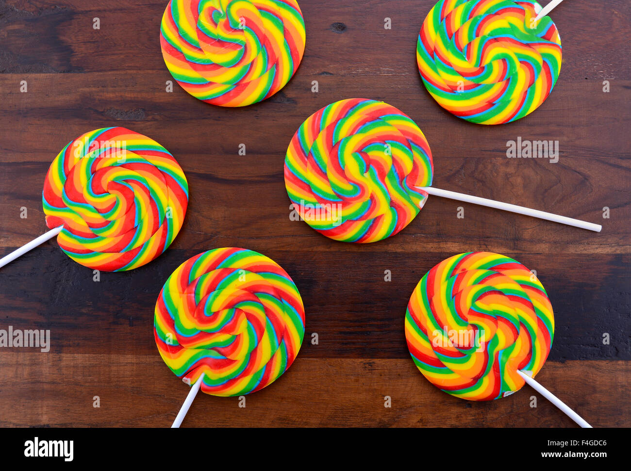 Bright rainbow lollipop candy on dark wood table Stock Photo - Alamy