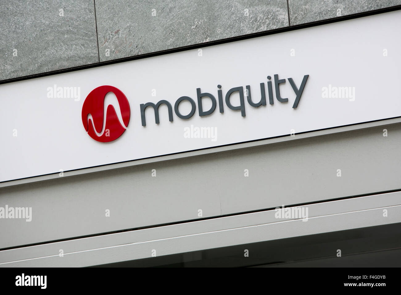 A logo sign outside of an office building occupied by mobiquity in ...