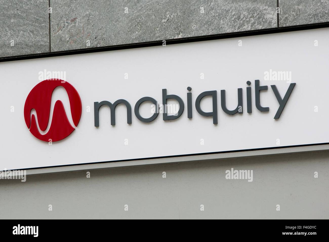 A logo sign outside of an office building occupied by mobiquity in ...