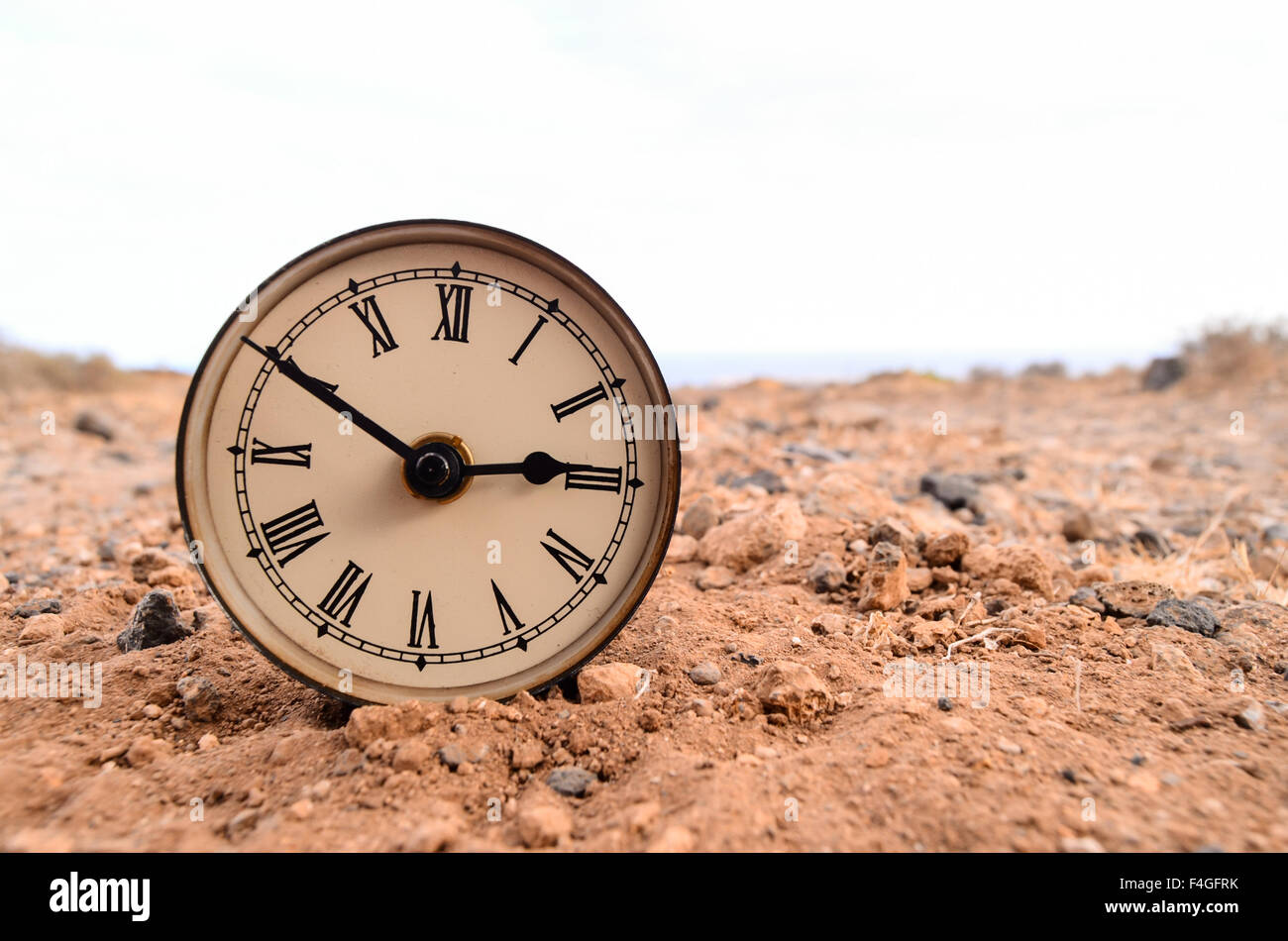 Classic Analog Clock In The Sand Stock Photo - Alamy