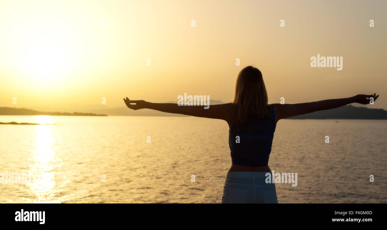 Woman with arms wide open at sunset Stock Photo - Alamy
