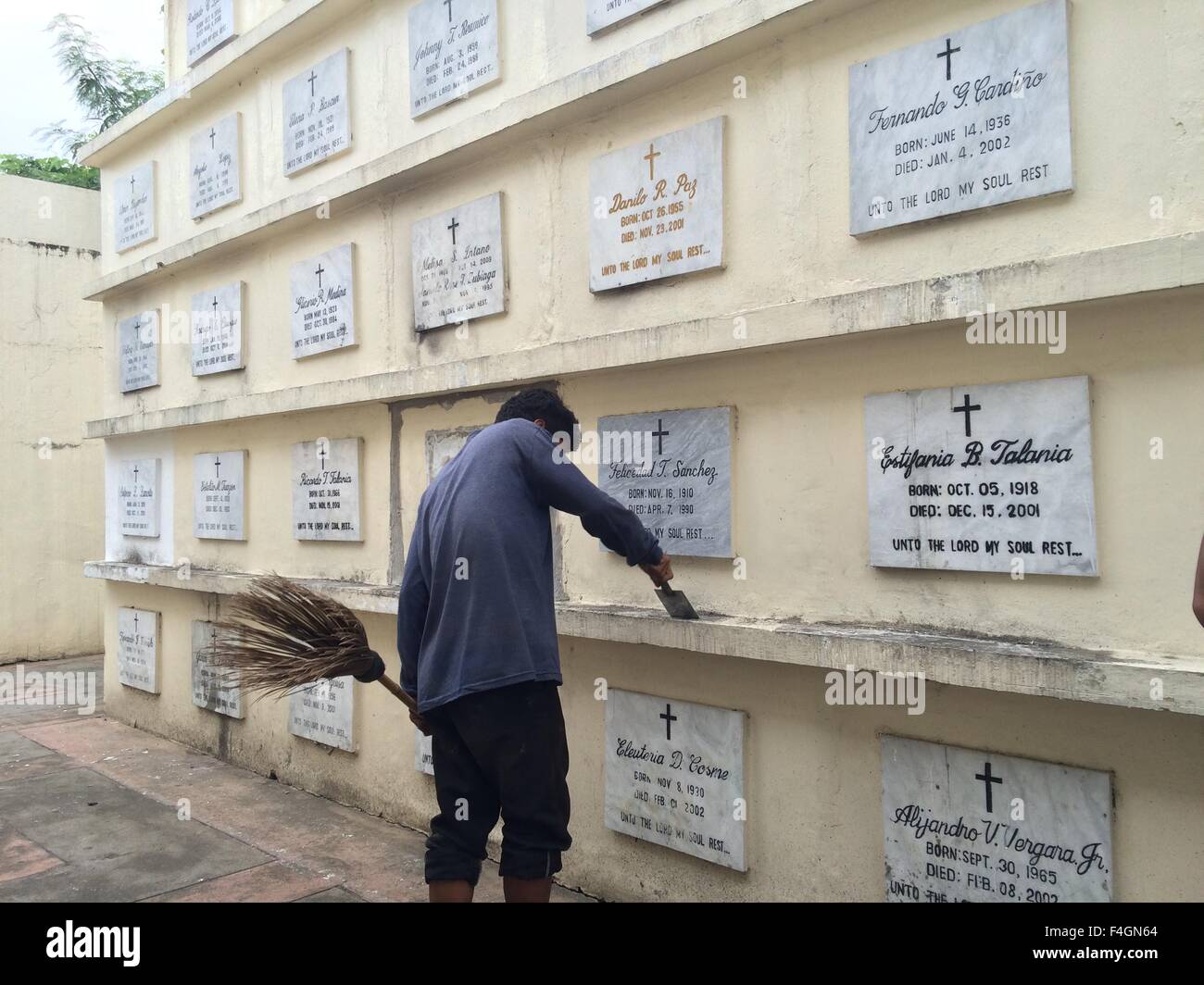 Las Pinas, Philippines. 18th Oct, 2015. Men cleaning up the tombs and ...