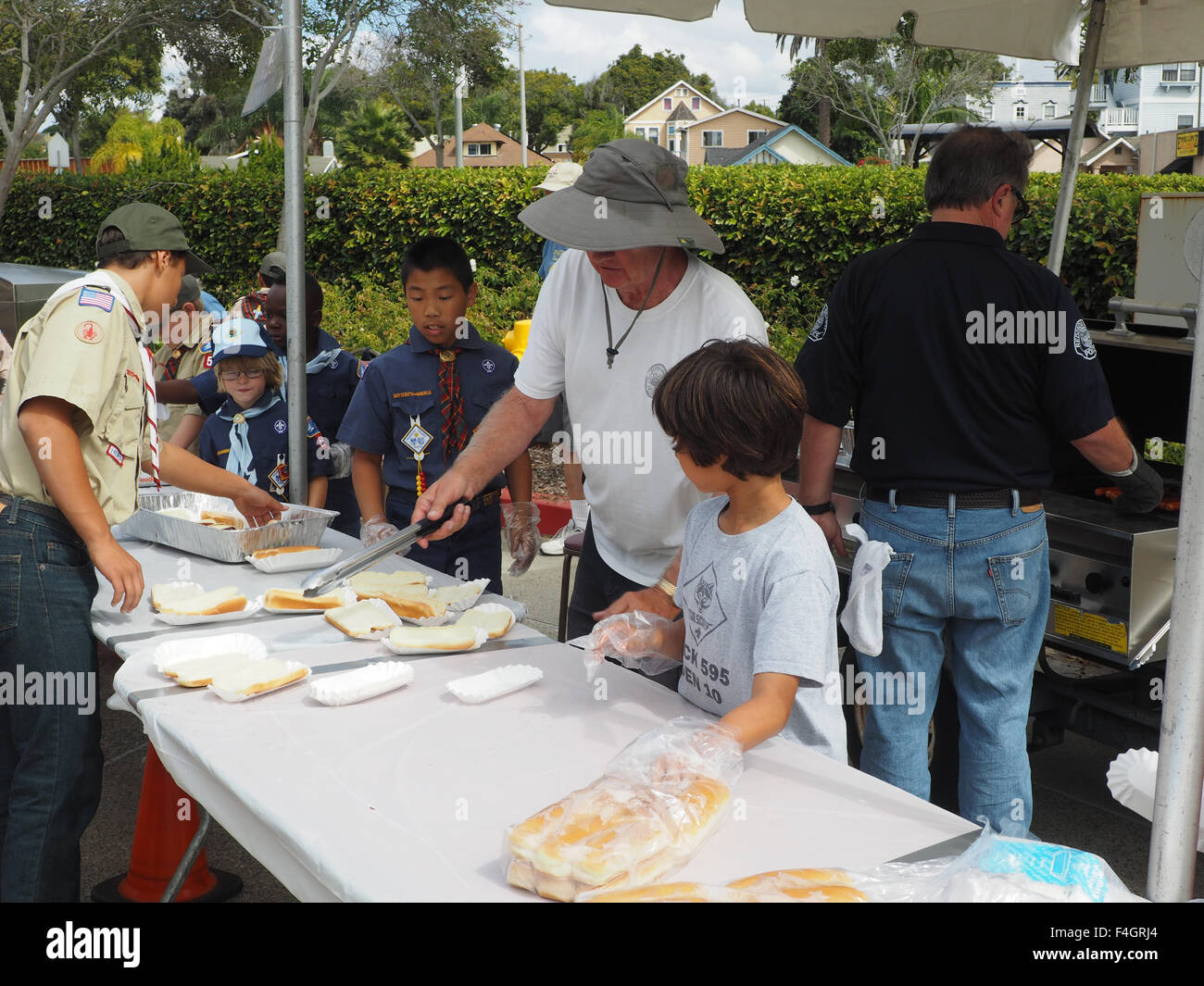 Senior helps scouts prepare hot dogs for police fair Stock Photo - Alamy