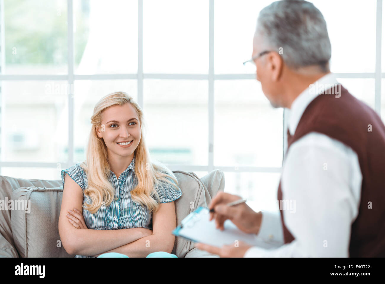 Smiling happy young woman talking with psychologist. Psychologist ...