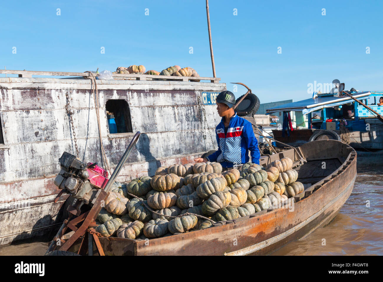 smaller boat being loaded with fruit melons for sale at Cai Rang ...