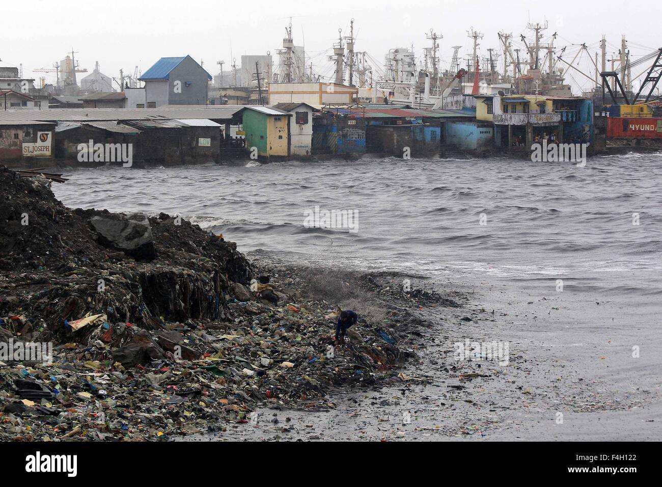 Navotas City, Philippines. 18th Oct, 2015. A man looks for reusable ...