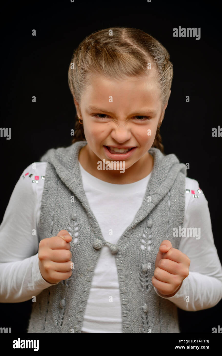 Do not yell on me. Little sullen moody girl holding hands in fists and ...