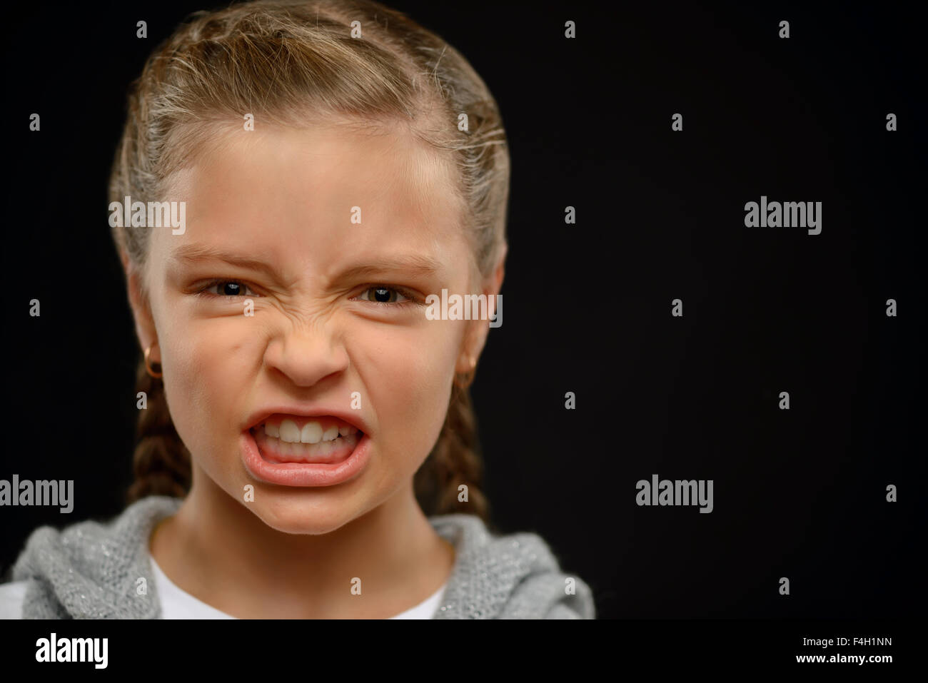 In a bad low mood. Portrait of little angry girl flying into a rage ...
