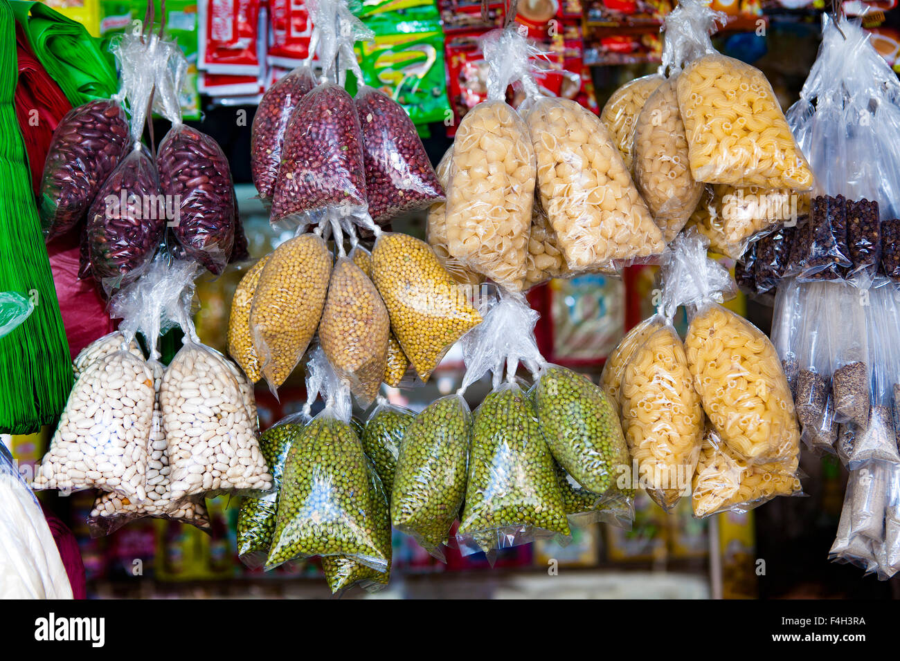 Plastic bags full of dried peas and beans hang in a roadside store in ...