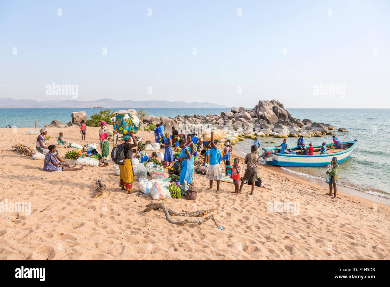 Local people unloading goods from a boat on the lakeside beach, Likoma ...