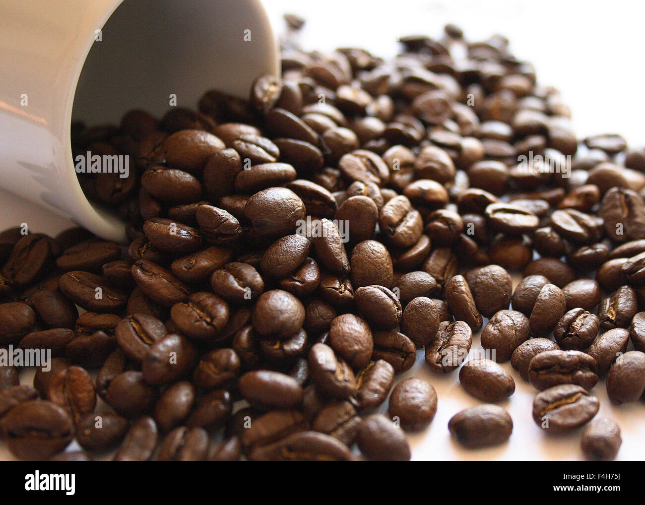 roasted coffee beans pouring from espresso cup Stock Photo - Alamy
