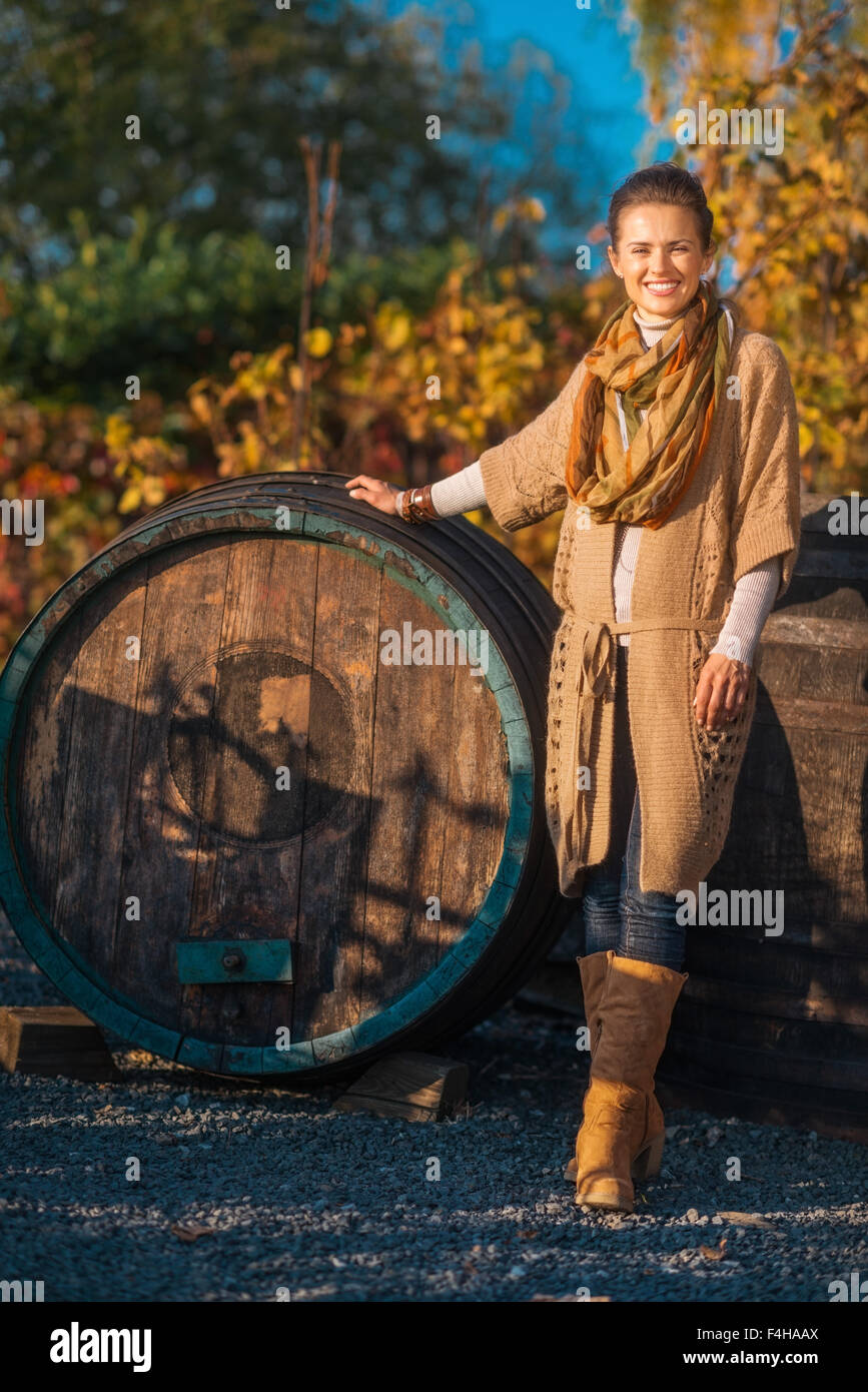 Full length portrait of smiling brunette woman winemaker standing near ...