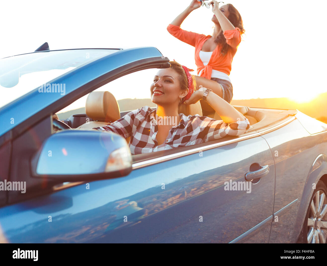 Two young happy girls driving a cabriolet Stock Photo - Alamy