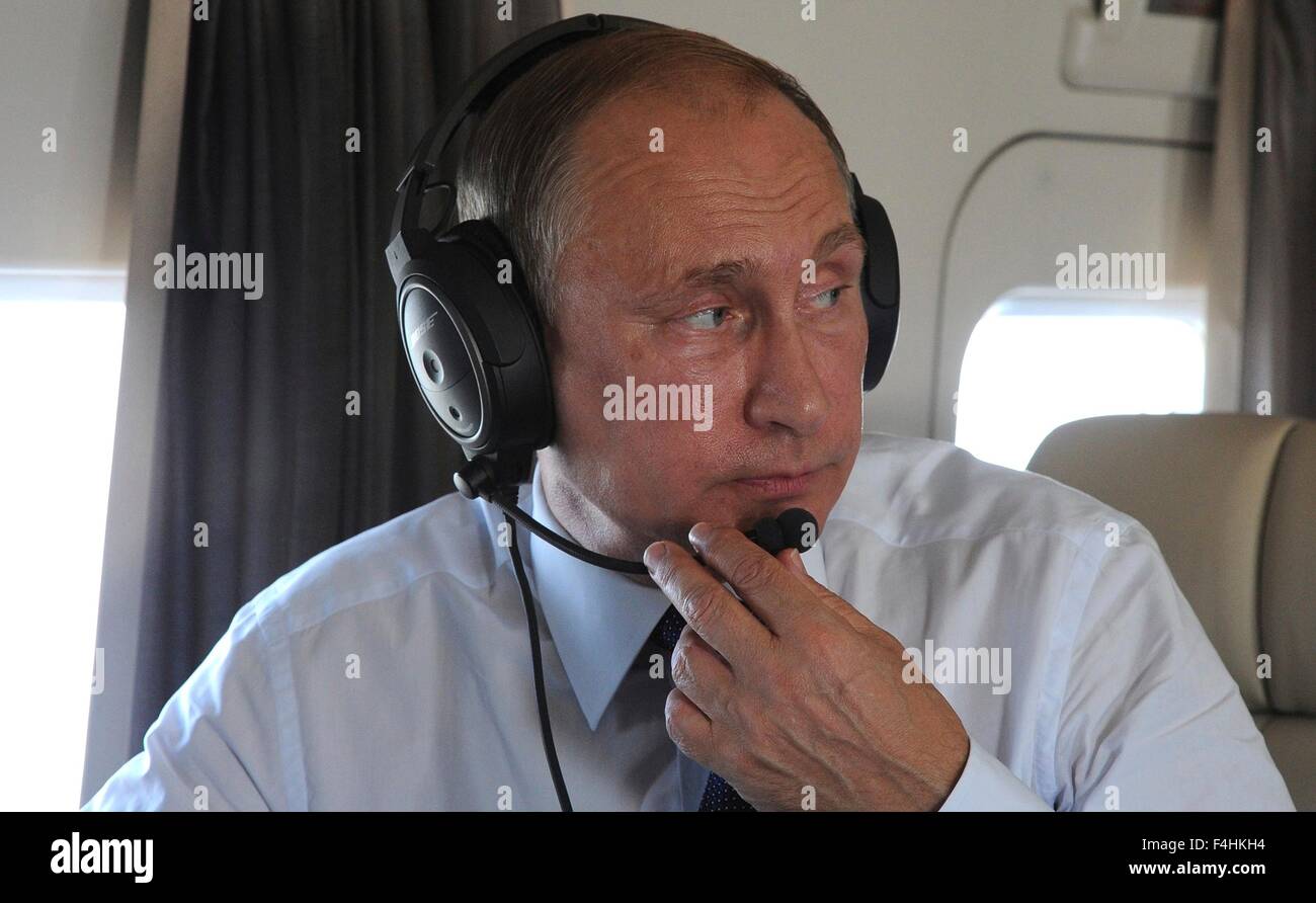 Russian President Vladimir Putin listens on a headset as he views ...