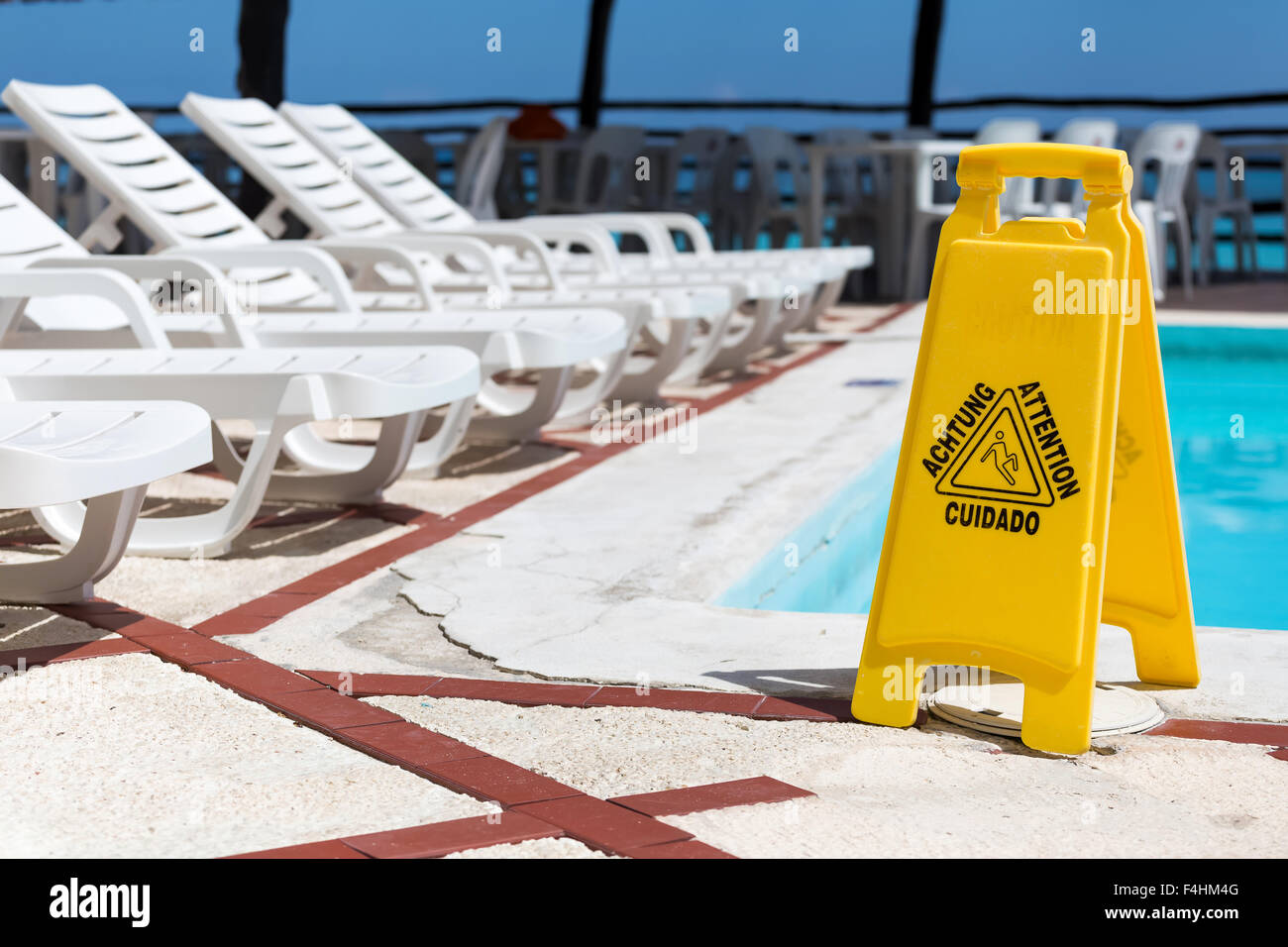 Wet floor warning sign near a swimming pool Stock Photo - Alamy