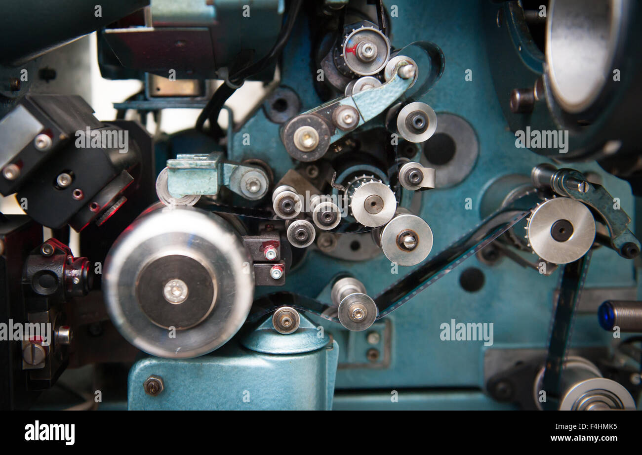 35 mm movie cinema projector detail with spool and film running, close ...