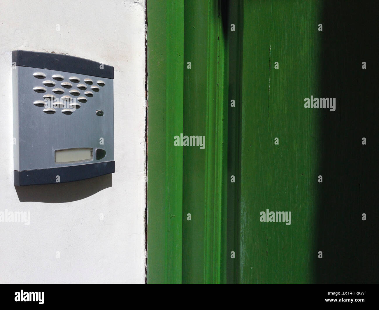 Old intercom over whitewashed wall, beside green wooden door Stock ...