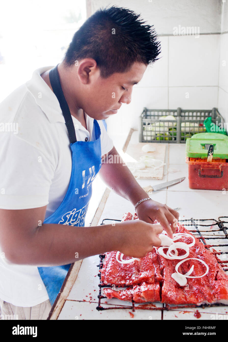 A cook prepares tikin xic, a whole fish that is rubbed with achiote ...