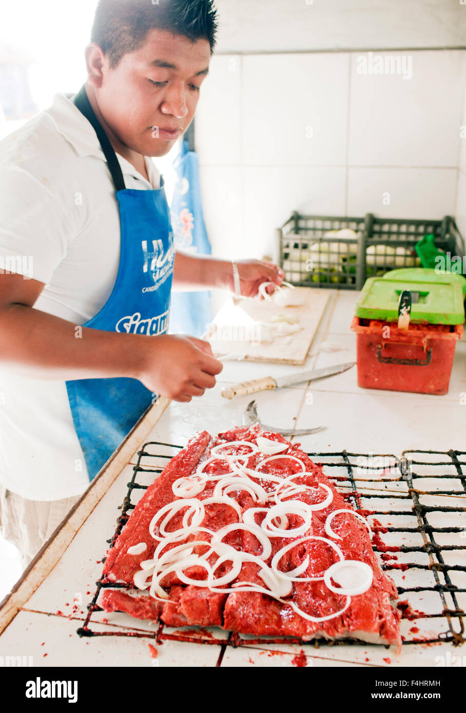 A cook prepares tikin xic, a whole fish that is rubbed with achiote ...