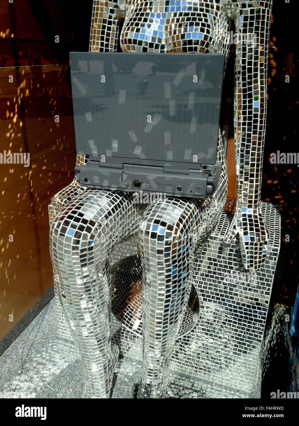 One thousand mirrors mannequin working with laptop at shop window Stock ...