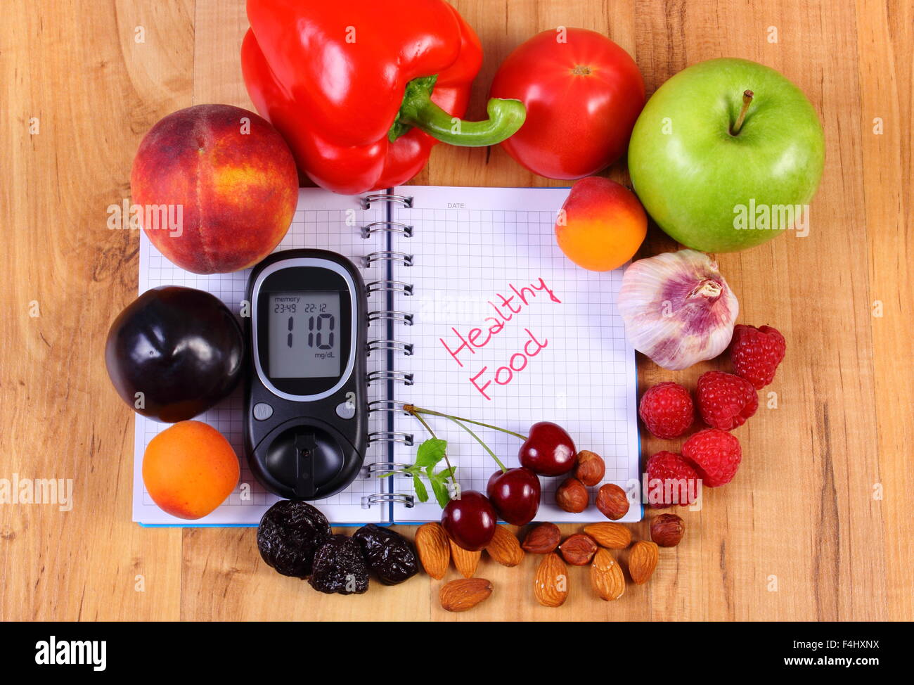 Fresh fruits, vegetables and glucose meter on notebook for writing ...