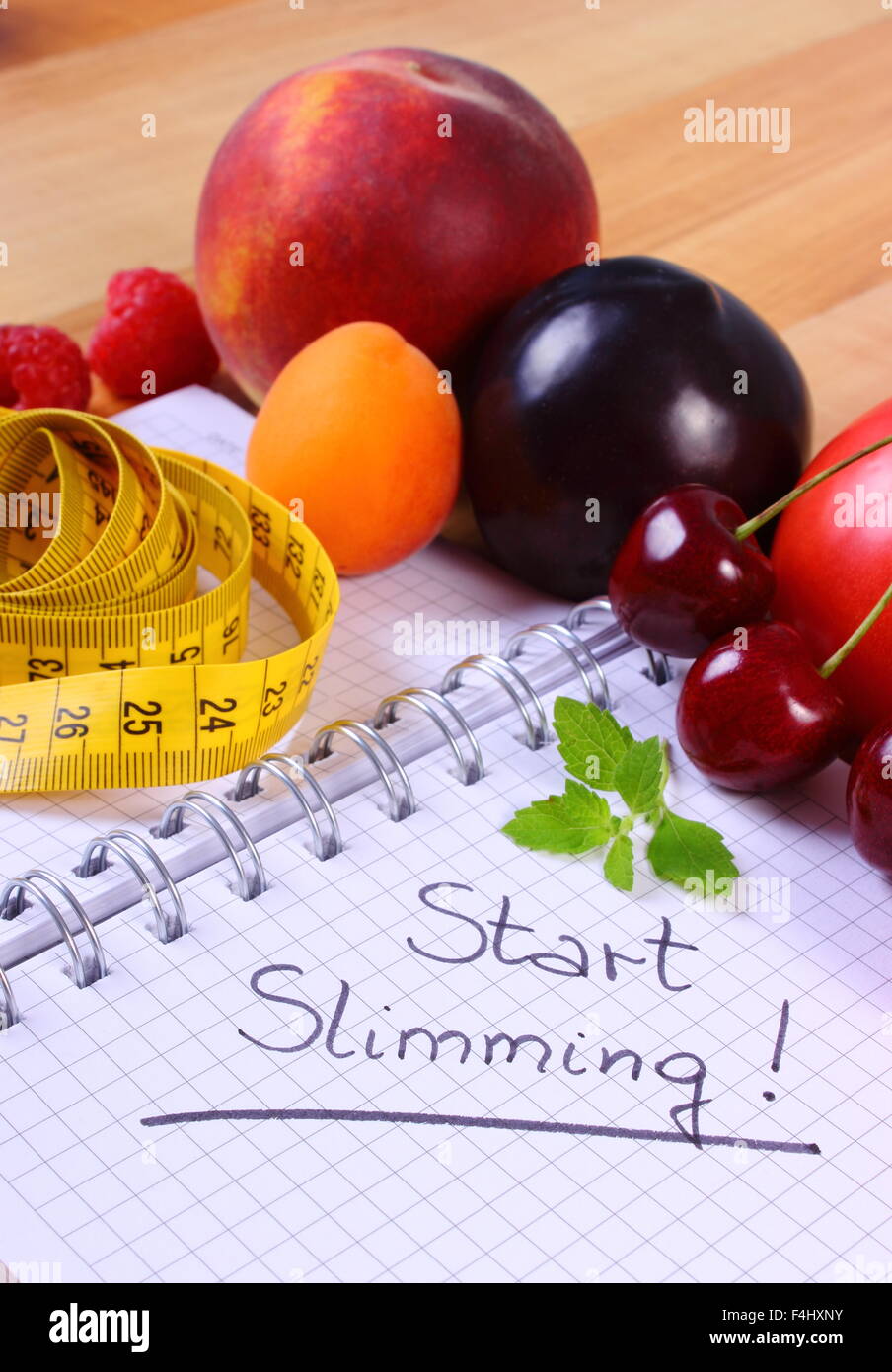 Fresh fruits and vegetables with tape measure and notebook for writing ...