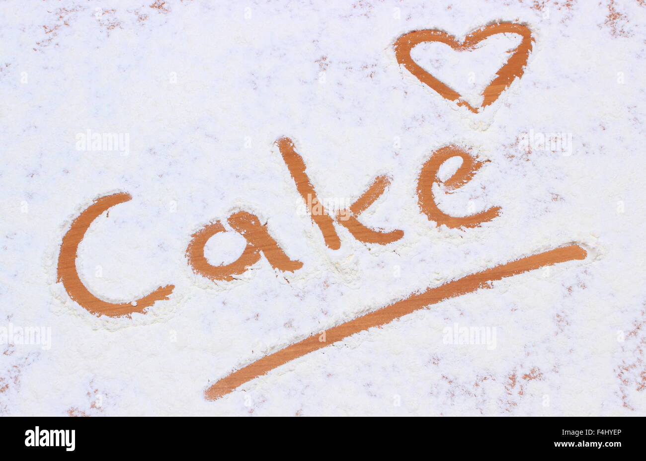 Word cake and heart shape written in white flour, concept of baking ...