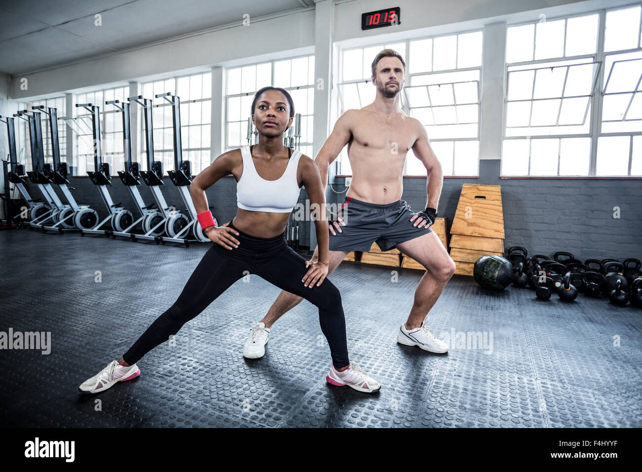 Muscular couple doing leg stretching Stock Photo - Alamy