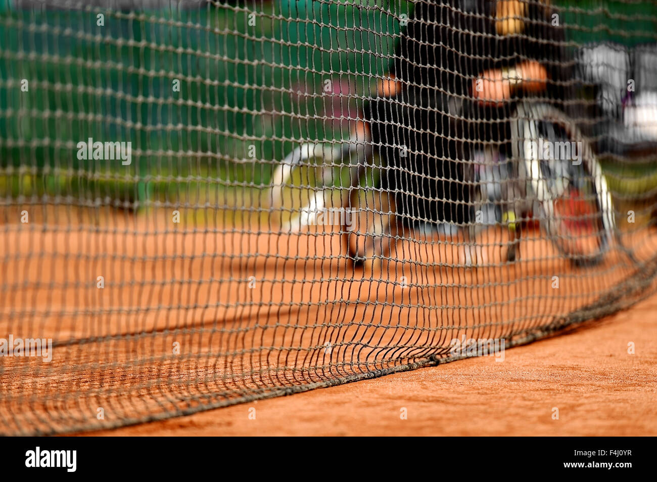 Unfocused wheelchair tennis player is seen behind a tennis net on a ...