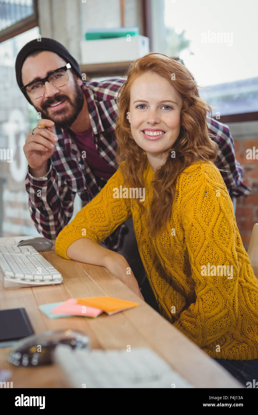 Portrait of smiling colleagues at office desk Stock Photo - Alamy