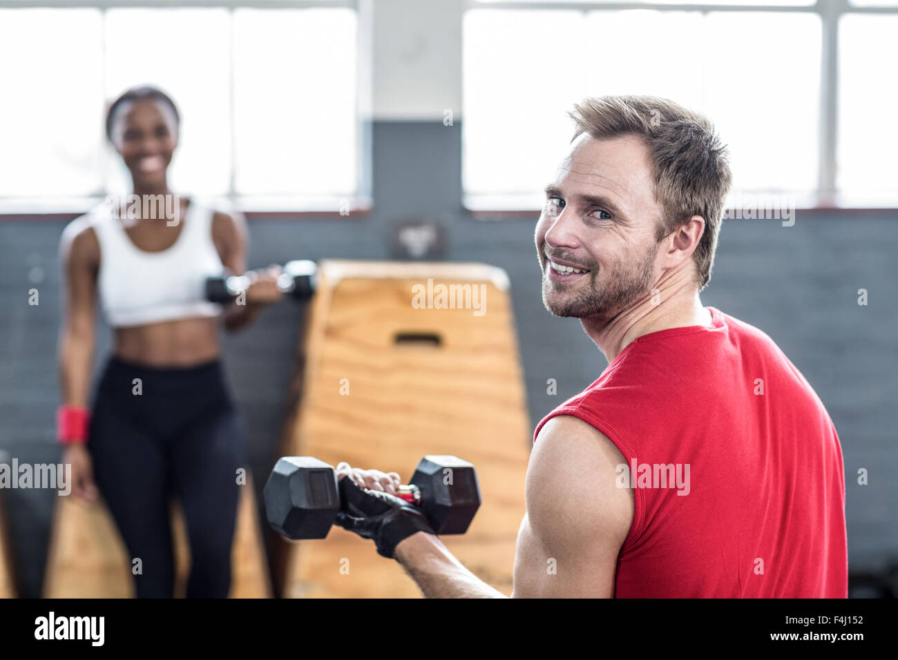 Muscular couple lifting weight together Stock Photo - Alamy