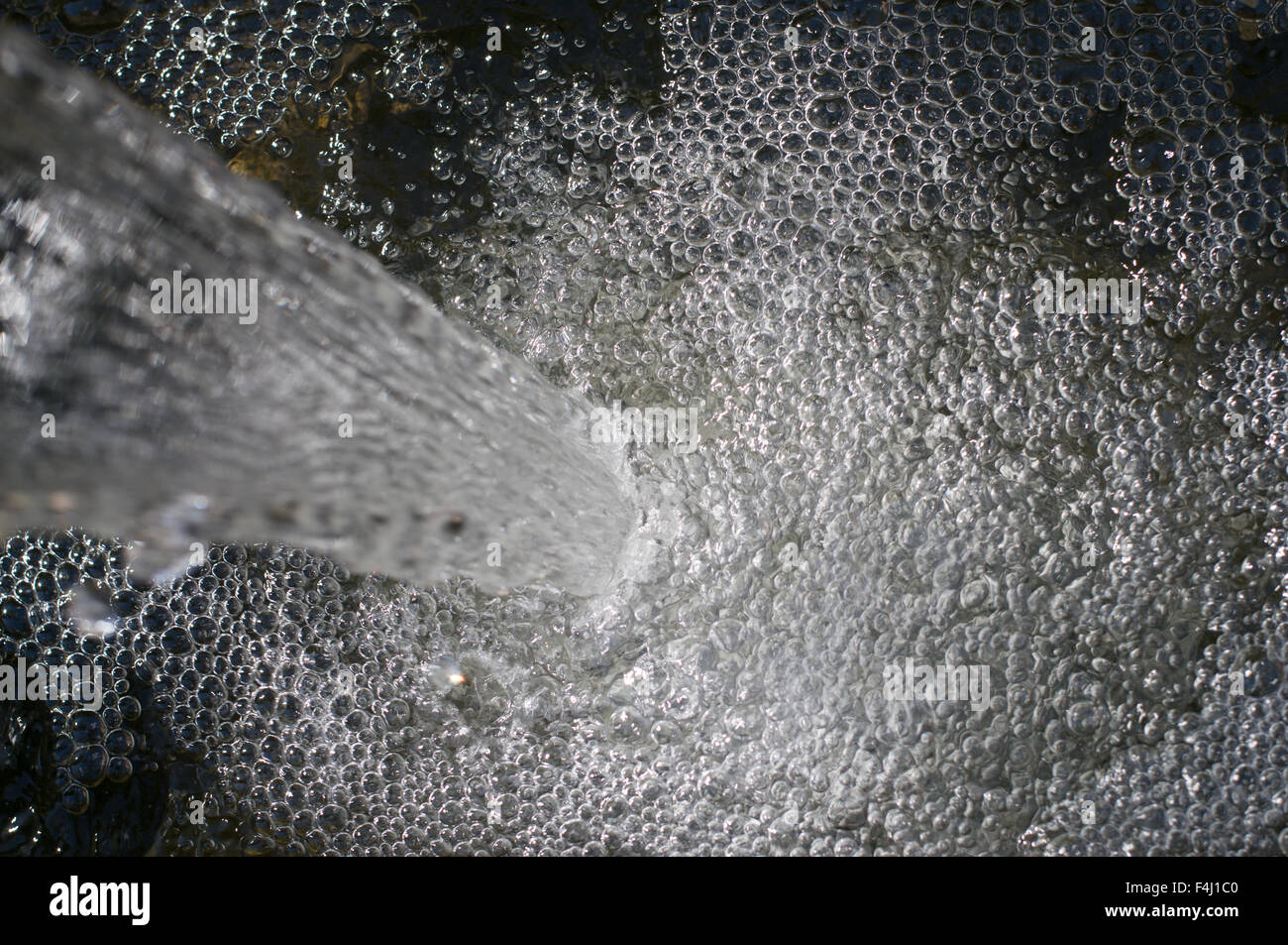 Water cascading into trough and forming bubbles Stock Photo - Alamy