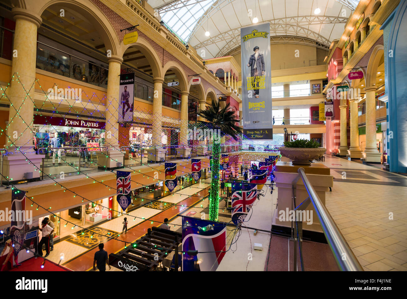 Many shops inside a new and colorful illuminated shopping mall, a ...