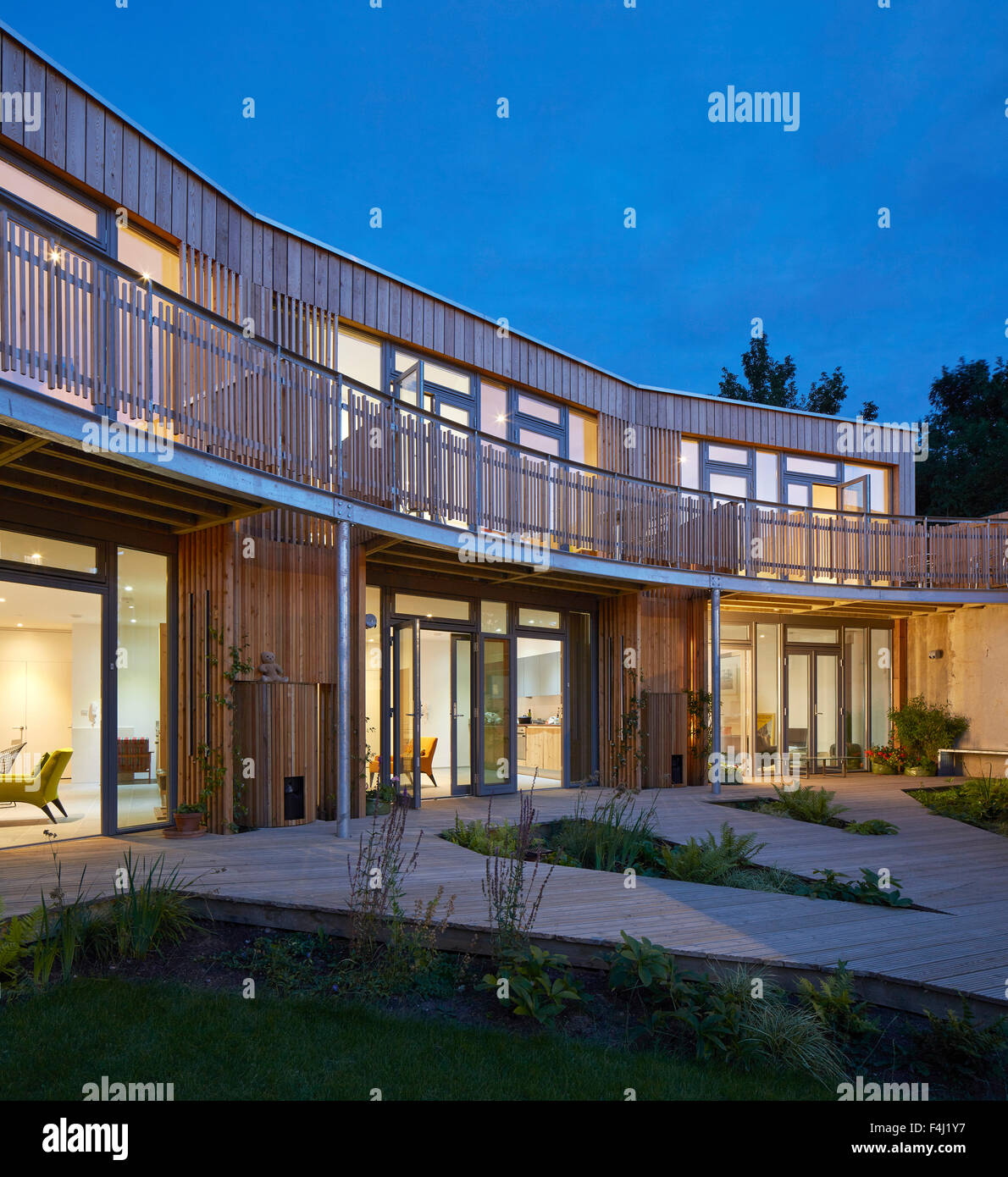 Dusk view through landscaped courtyard. Eco Vale, London, United ...