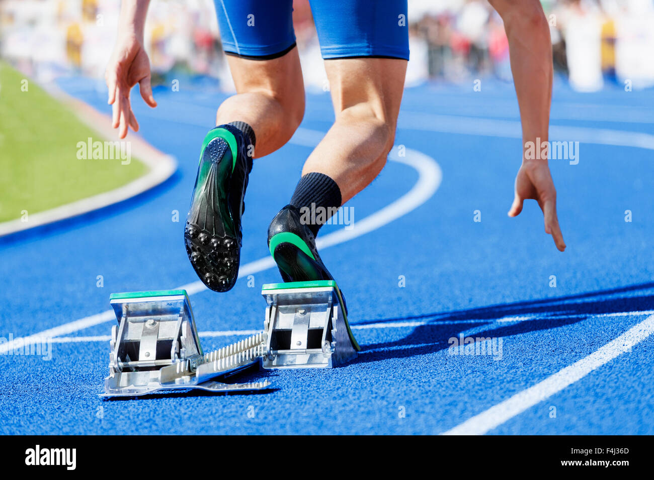 Track and field runner starts out of the blocks Stock Photo - Alamy