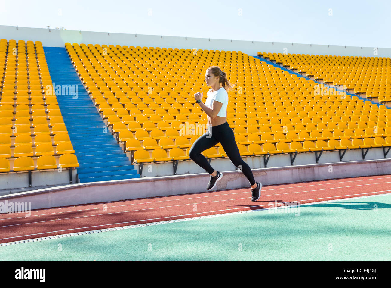 Full length portrait of a fitness woman running at stadium Stock Photo ...