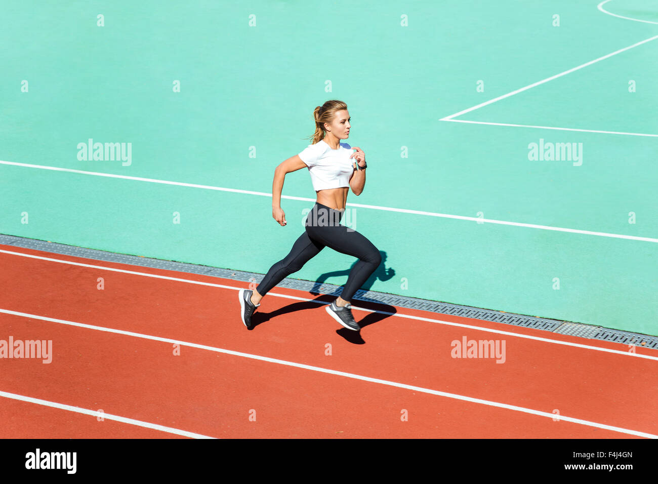 Portrait of a beautiful fitness woman running at stadium Stock Photo ...