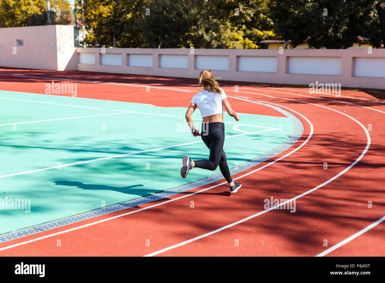 Portrait of a woman running at stadium Stock Photo - Alamy
