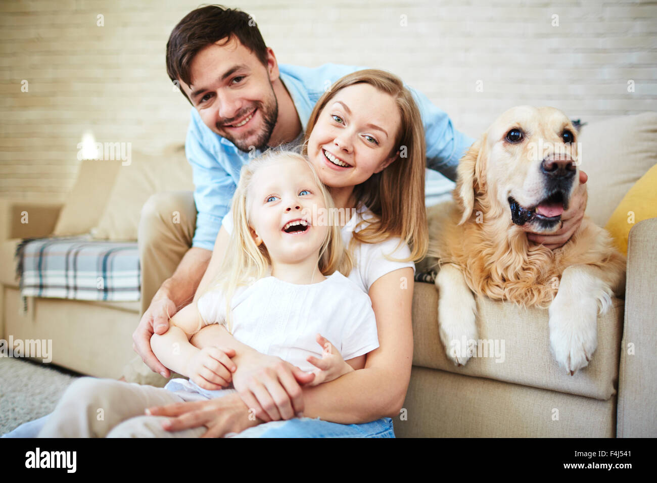 Happy family having home rest with their pet Stock Photo - Alamy