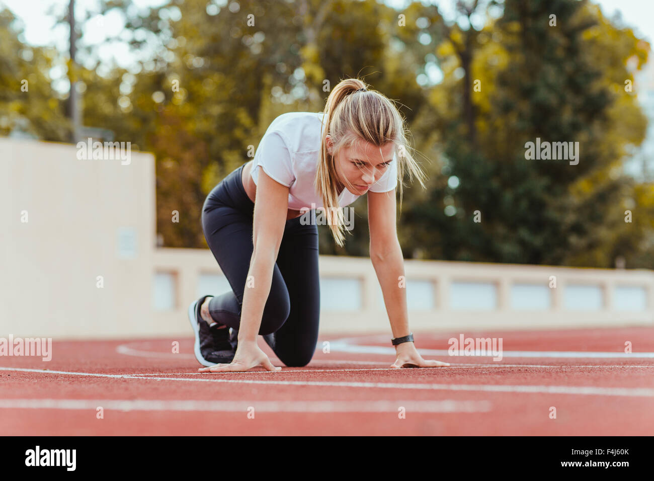 Beautiful sports woman standing in start position for run on outdoor ...