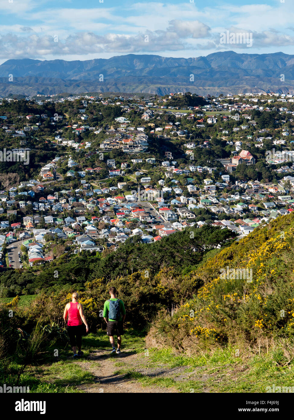 Suburbs and Rimutaka Ranges from Kingston with couple on walking track ...