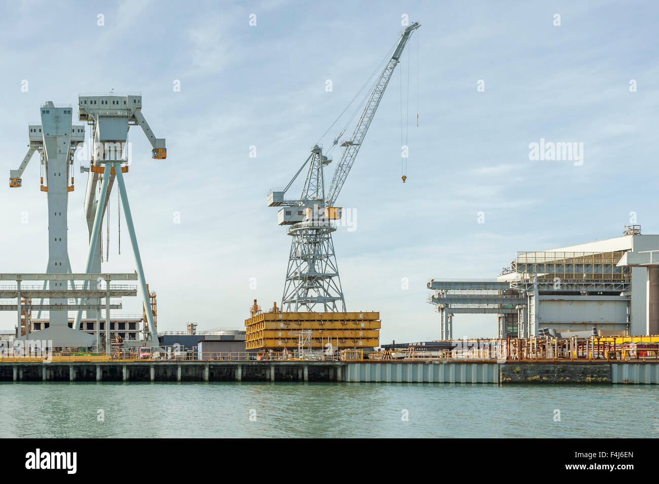 Various types of cranes at work in a shipyard Stock Photo - Alamy
