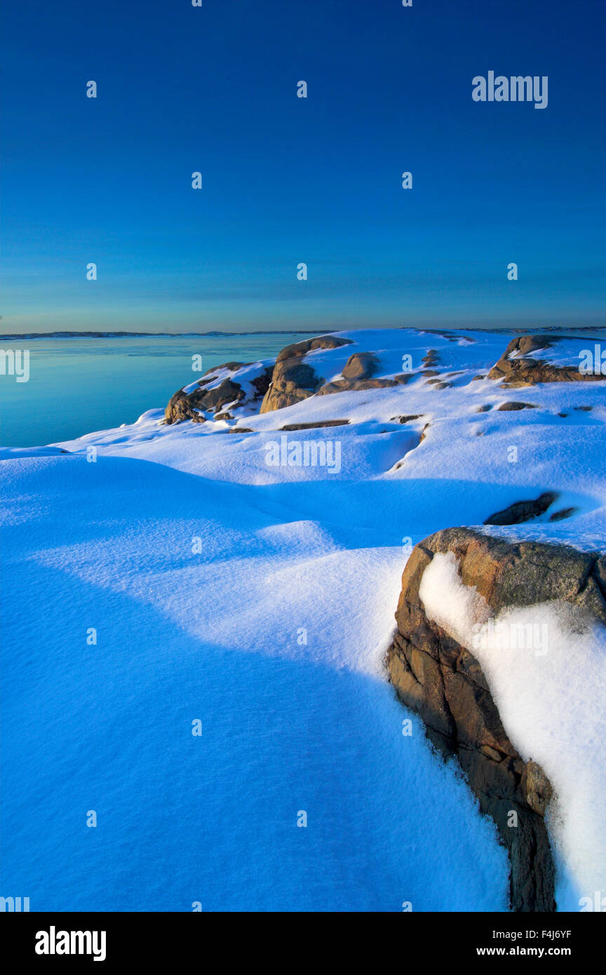 Snow on cliff by the ocean Stock Photo - Alamy