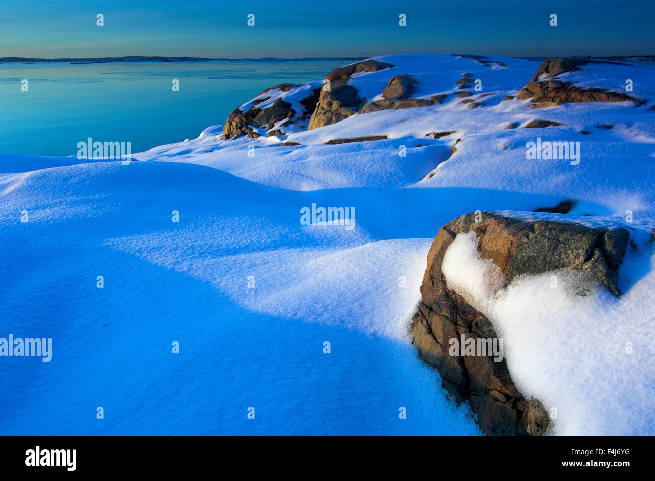 Snow on cliff by the ocean Stock Photo - Alamy