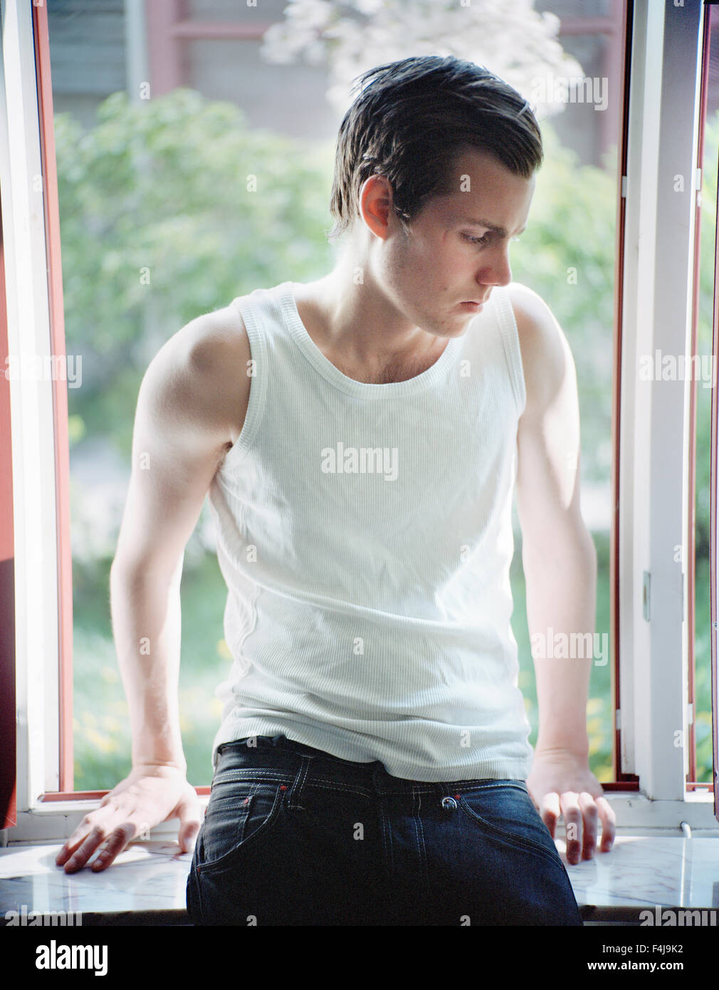 A man sitting in a window Stock Photo - Alamy