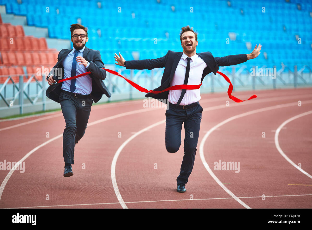 Young businessmen running on stadium Stock Photo - Alamy